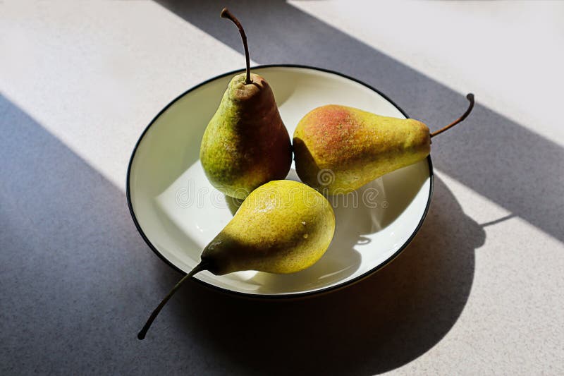 Three Pears on a Plate on the Kitchen Table, Shadows from Objects Stock ...