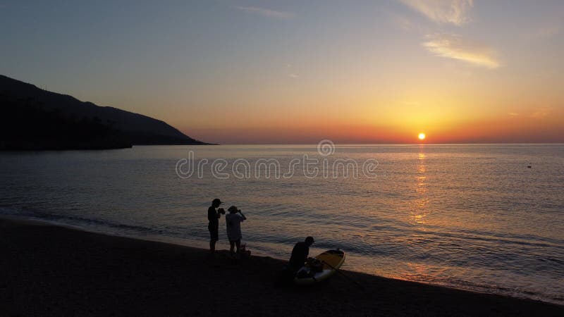 Three People on the Beach Meet the Sunset Stock Photo - Image of ocean ...