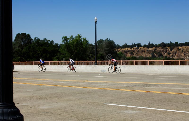 Three People Cycling Over Bridge with Blue Sky Editorial Photo - Image ...