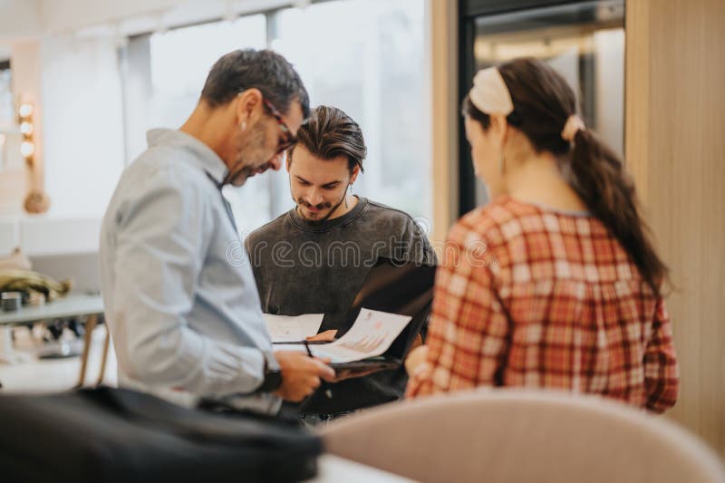 Multi Generational, Business Colleagues Collaborating on Project in ...