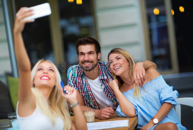 Three People Having Fun in Cafe Stock Photo - Image of cheering, drink ...