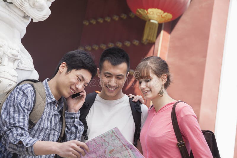 Three People Looking at Map. Stock Image - Image of holding, vertical ...