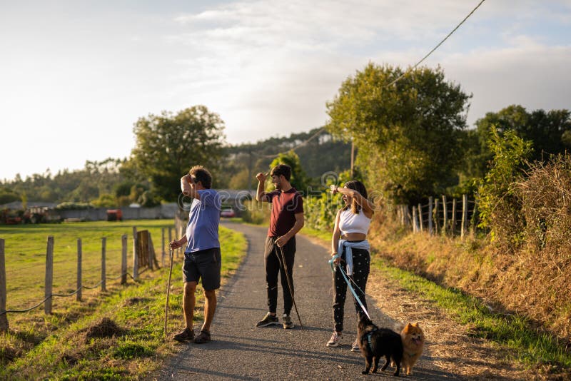 Three People Observing the Landscape in the Nature at Sunset with Two ...
