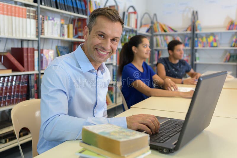 Three People Sat at Library Table Mature Man Using Laptop Stock Image ...