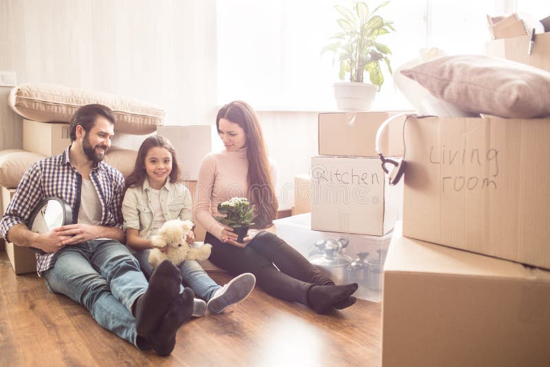 Three People are Sitting Together on the Floor. they are Surrounded ...