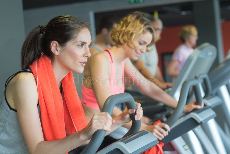 Three People Stepping on Step Machine in Gym Stock Photo - Image of ...