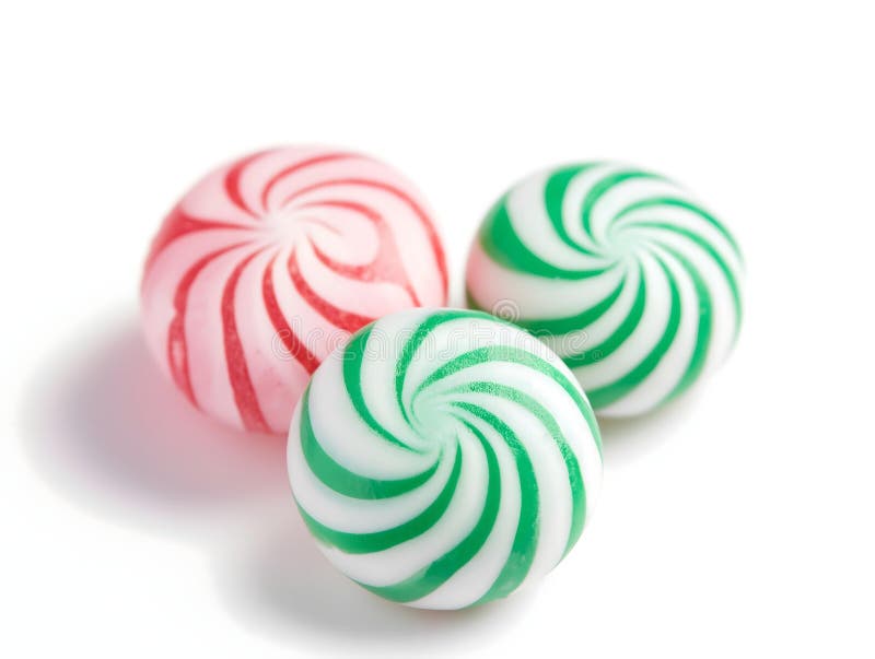 Three Peppermint Swirl Candies in Pink and Green, Arranged on a White ...
