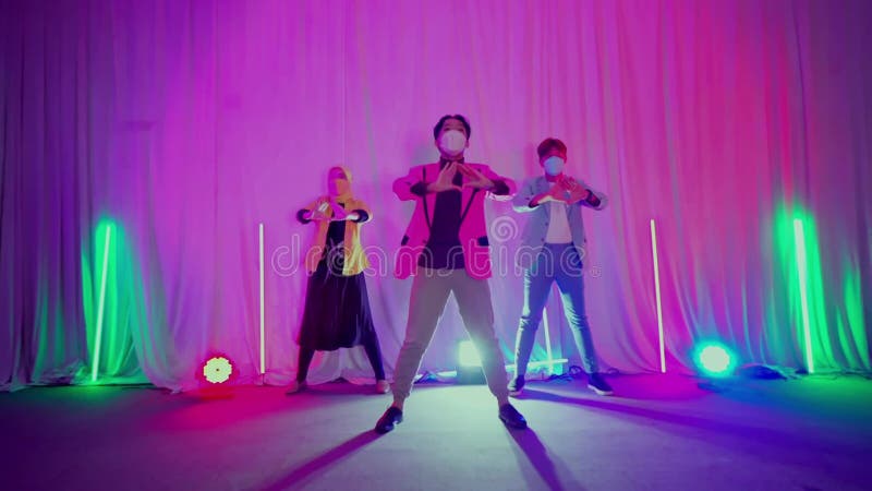 Three Performers on Stage with Colorful Stage Lighting, Showcasing a ...