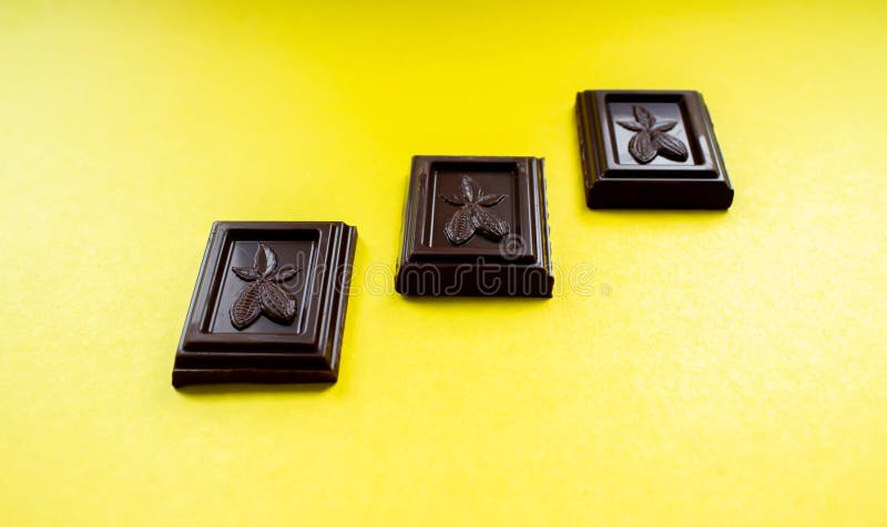 Pieces of Chocolate with Hazelnuts on a Yellow Background Stock Image ...