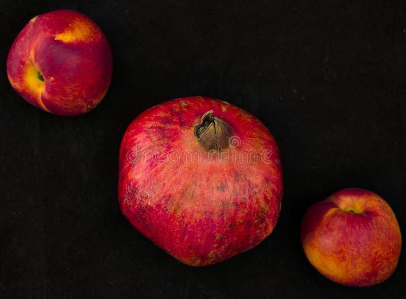 Three Pieces of Fruit, a Pomegranate and Two Peaches Stock Image ...