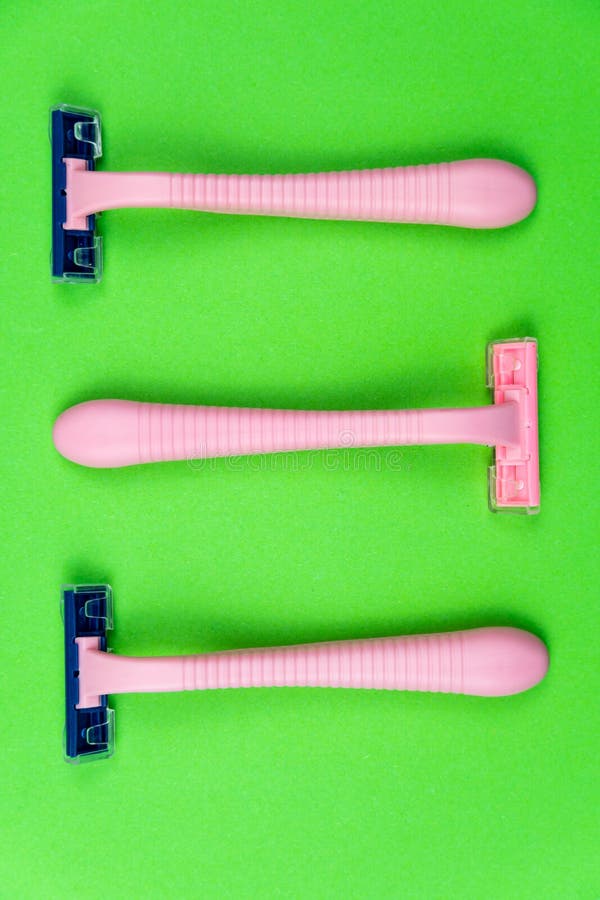Three Pink Disposable Razors on a Green . Personal Hygiene Items for ...