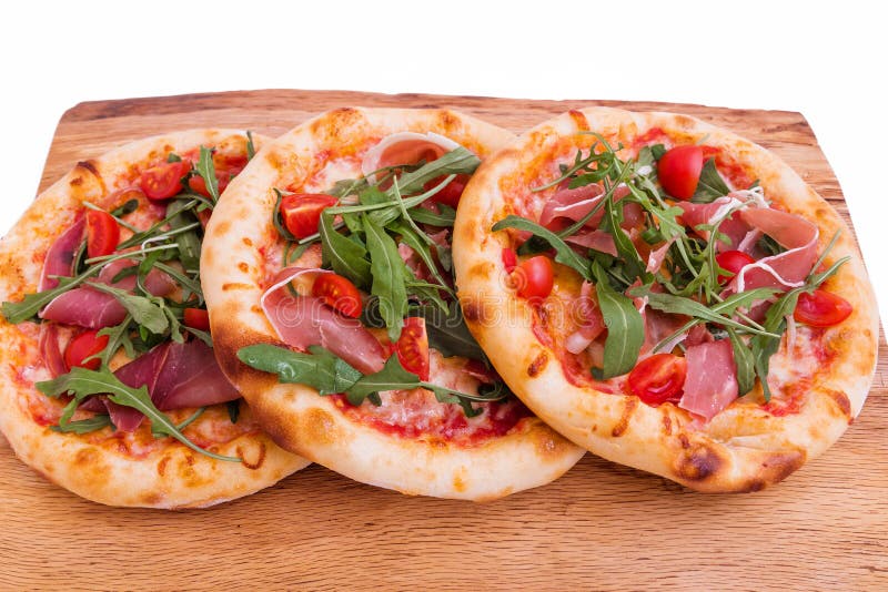 Three Pizzas with Ham, Tomatoes, Arugula on a Wooden Tray Stock Photo ...