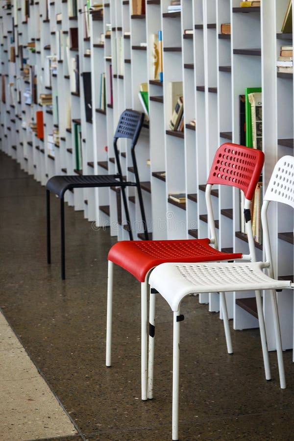 Three Plastic Chairs Standing Near Shelves with Books in Library Stock ...