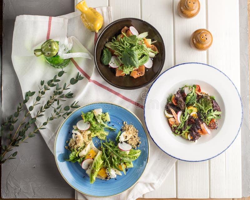 Three Plates Set of Green Healthy Salad on White Table Restaurant Menu ...