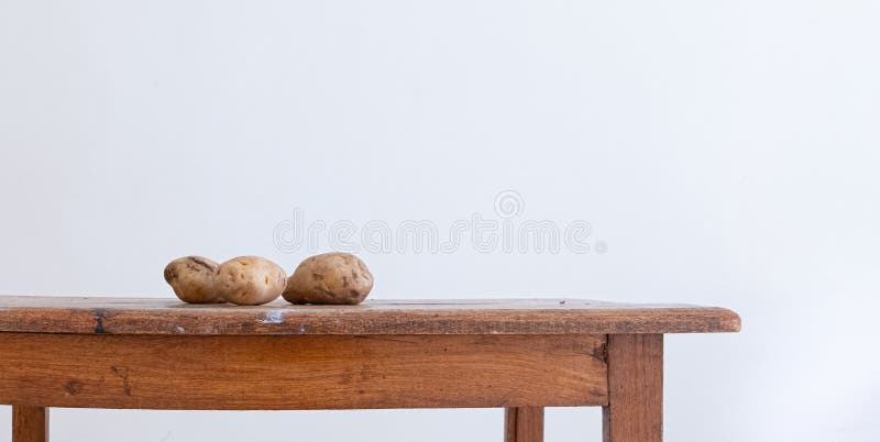 Three Potatoes on the Table Stock Photo - Image of paper, vegetables ...
