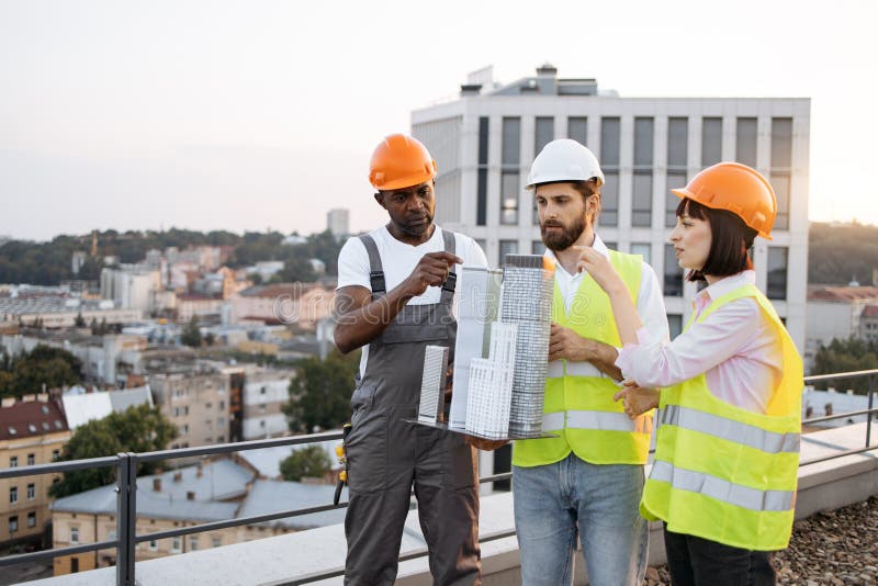 Three Project Managers Inspecting Reduced Copy of Building Stock Photo ...
