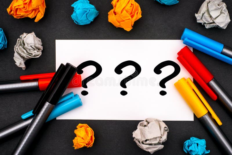 Three Question Marks on White Paper Blank with Colour Pens and Crumpled ...