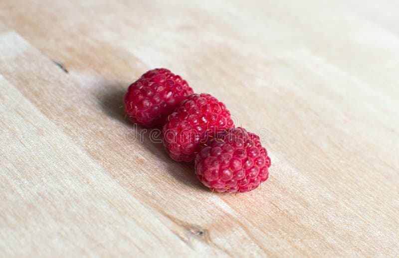 Three Raspberries on Wooden Desk. Closeup Diagonal Composition Stock ...