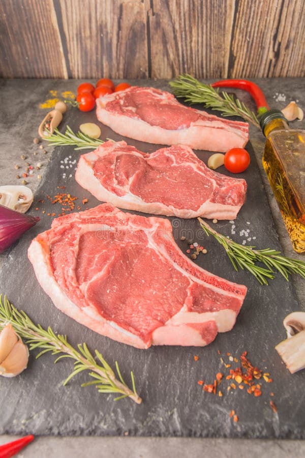 Three Raw Steaks on Black Slate, Side View Stock Image - Image of grill ...