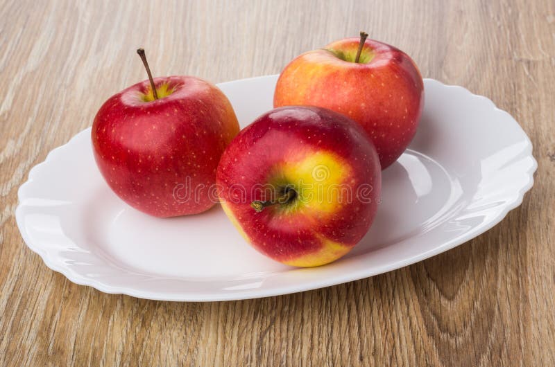 Three Red Apples in Oval Dish on Table Stock Photo - Image of food ...