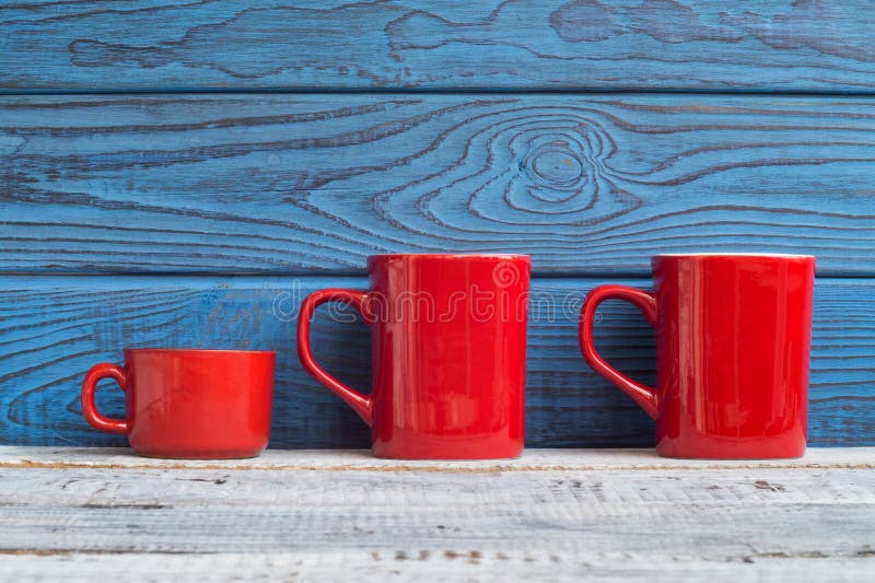 Three Red Coffee Cups on a Background of Blue Boards Stock Image ...
