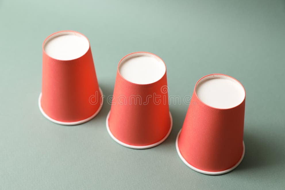 Three Red Cups on Pale Olive Background. Thimblerig Game Stock Image ...