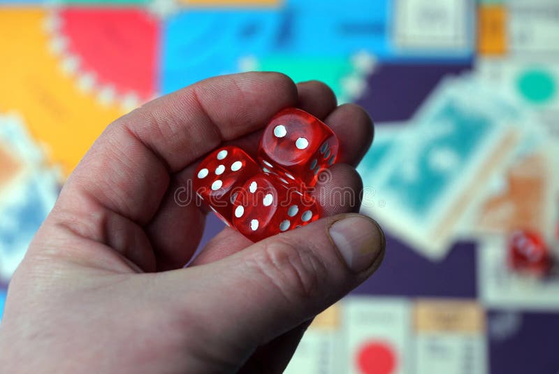 Three Red Dice Cubes on the Palm Above the Board Game Stock Image ...