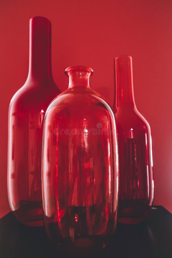 Three Red Glass Bottles Against Red Background Stock Photo - Image of ...