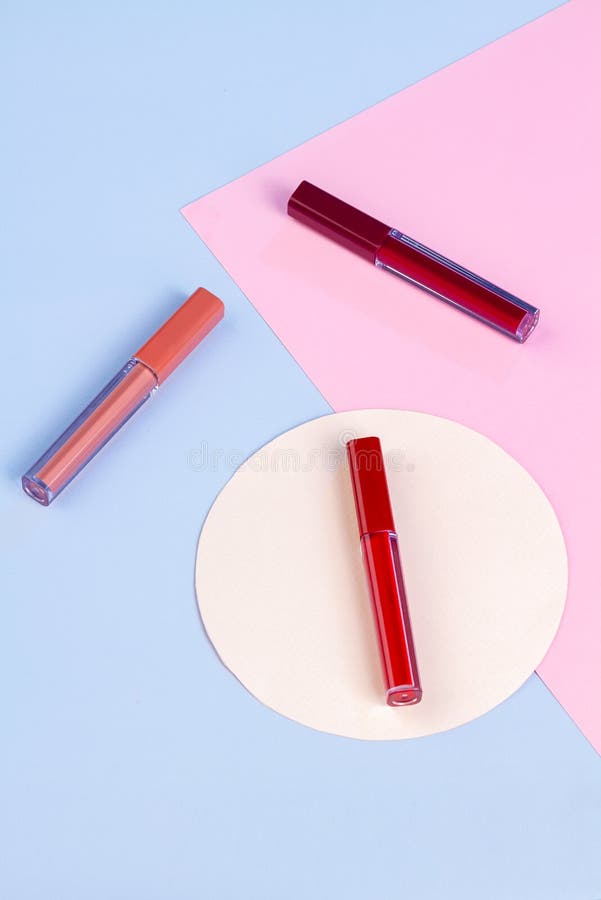 Three Red Lip Gloss Sticks on Light Blue Background. Stock Photo ...
