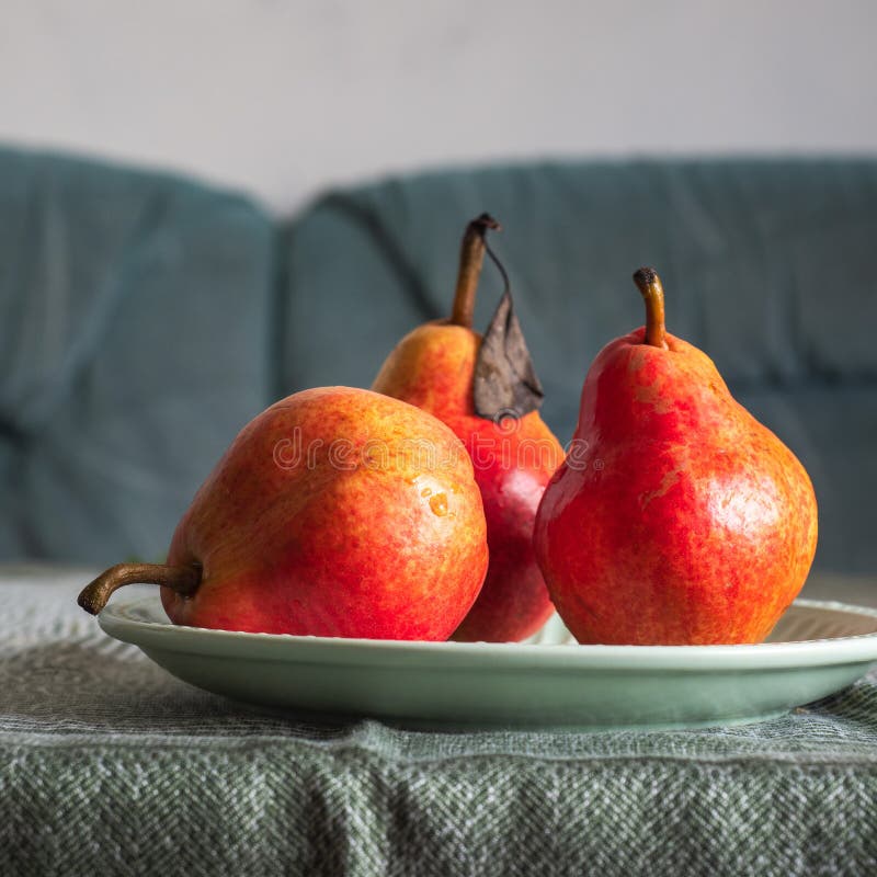 Three Red Pears on a Green Plate Standing on a Table Covered Stock ...