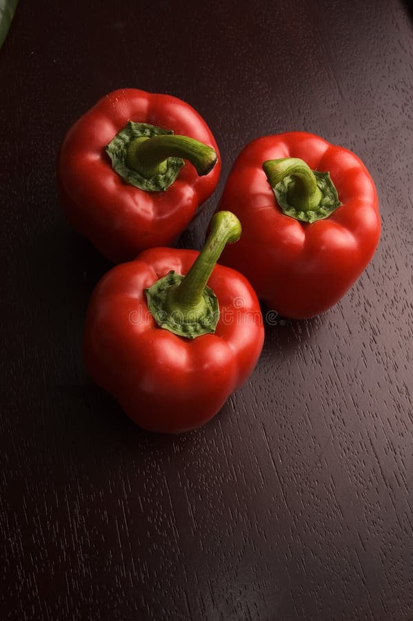 Three Red Peppers on Dark Wood 2 Stock Photo - Image of meeting, three ...