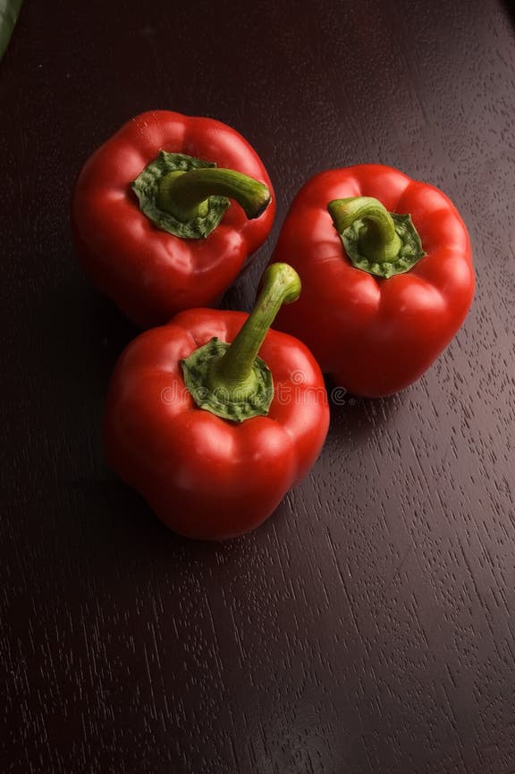 Three Red Peppers on Dark Wood 2 Stock Photo - Image of meeting, three ...