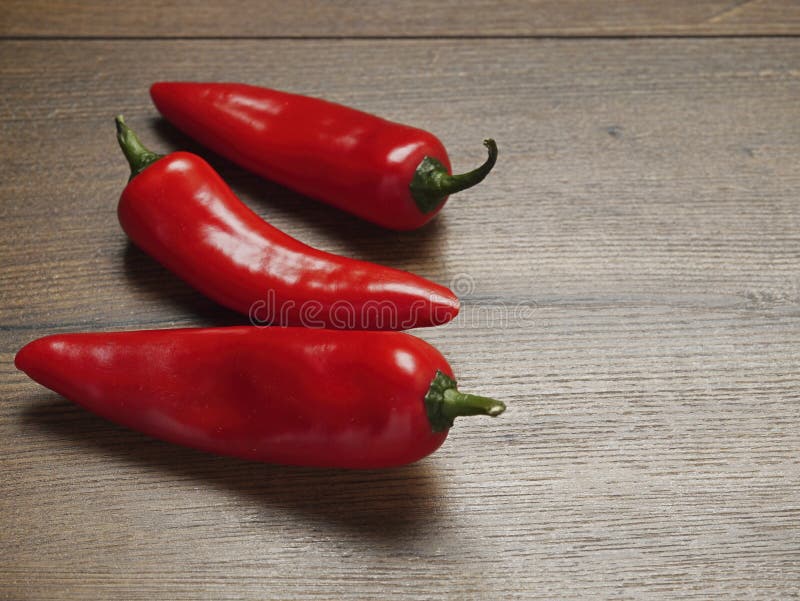 Three Red Peppers on a Wooden Table, Copy Space, Wood Texture. Still ...