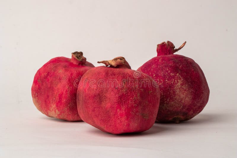Three Red Pomegranates with a Dry Rough Skin on a Light Background ...