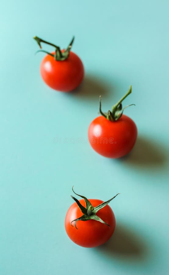 Three Red Tomatoes on a Green Background, Vertical Format Stock Image ...