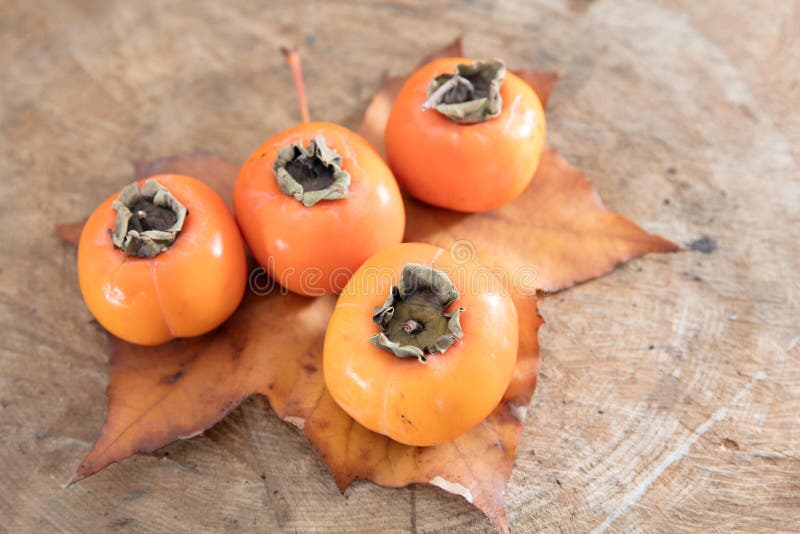 Three Ripe Crispy Persimmons on a Yellow Leaf Stock Image - Image of ...