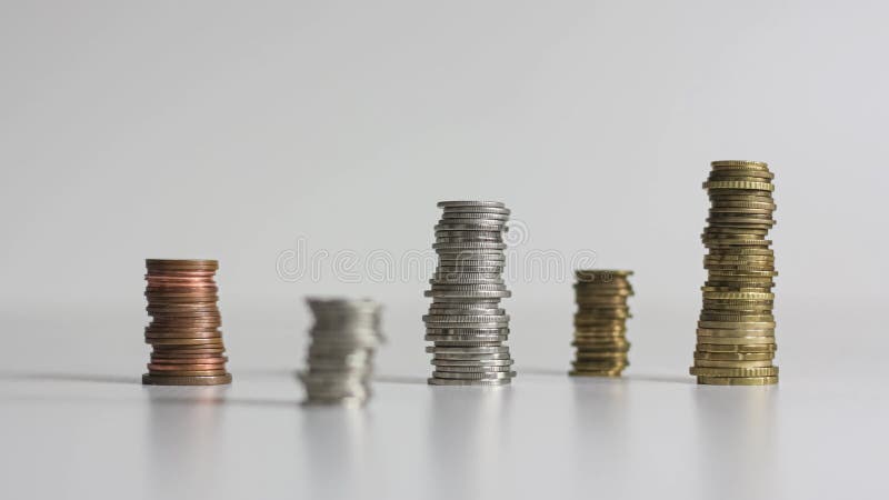 Three Rising and Falling Stacks of Copper, Silver and Golden Coins on a ...