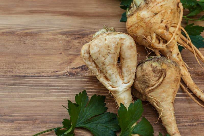 Three Root Crops of Parsnip on a Light Brown Wooden Surface, on the ...