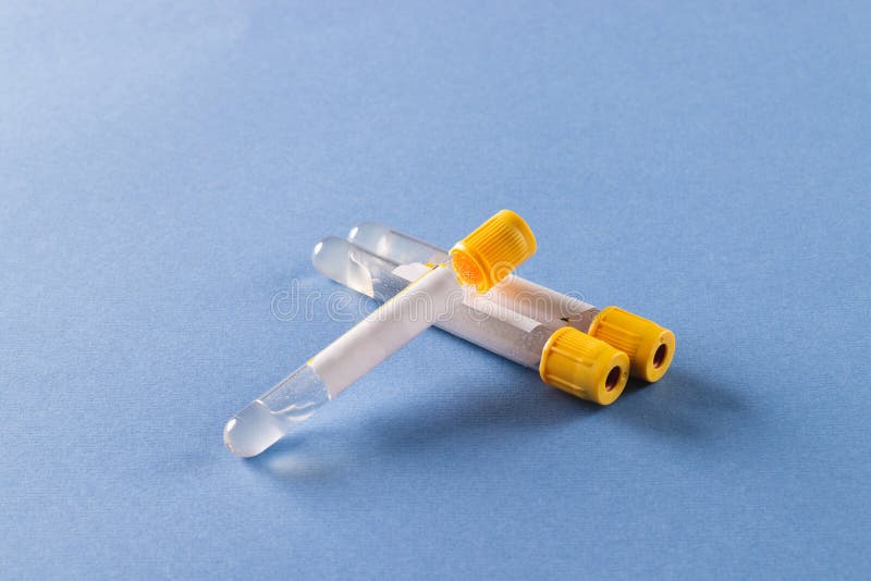 Three Sample Tubes of Clear Fluid with Yellow Lids, on Blue Background ...