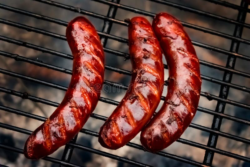 Three sausages on a grill. stock image. Image of meat - 179656595