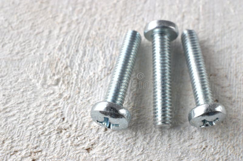 Three Screws on a White Wooden Table Stock Image - Image of object ...