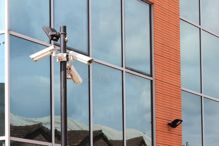 Three Security Cameras on Front of Glass Building Stock Image - Image ...
