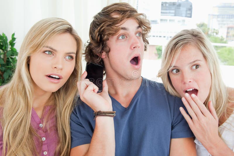 Three Shocked Friends Listening To a Phone Conversation Stock Photo ...