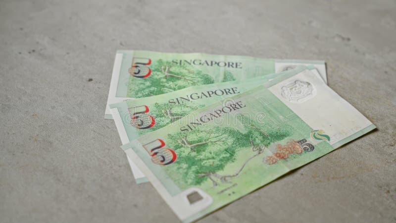 Three Singapore Dollars Banknotes on Concrete Surface Showcasing ...
