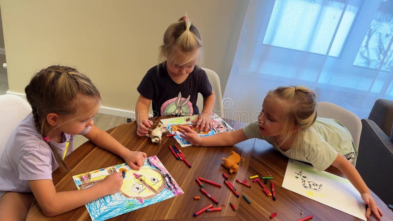 Three Sisters Triplets Drawing with Felt-tip Pens on A4 Sheets Sitting ...