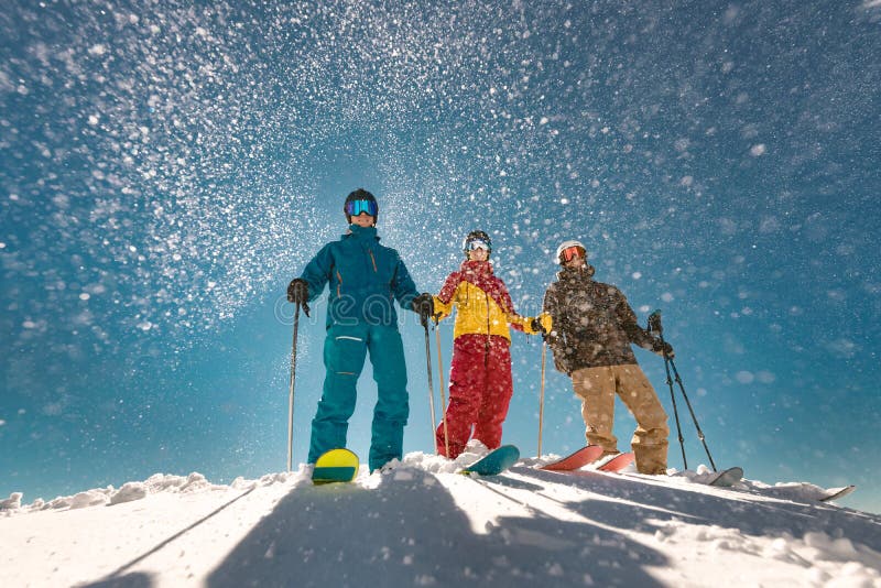 Three Skiers Stands Against Sun and Snowfall Stock Photo - Image of ...
