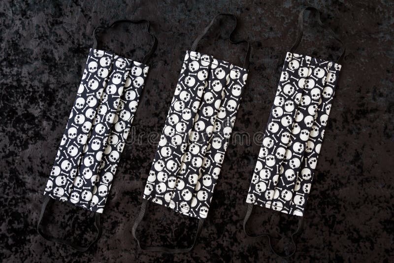 Three Skull and Bones, Black and White Fabric Face Masks, on a Black ...