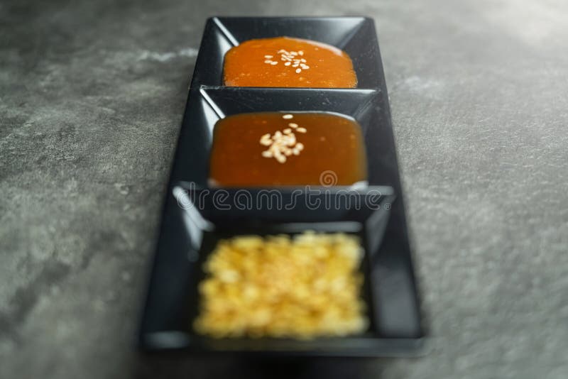 Three Small Black Plates with Sauces on Them Stock Photo - Image of ...