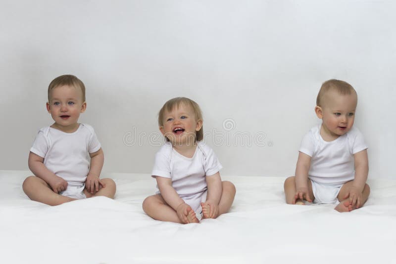 Three Small Children Sit on a White Background and a Smile Stock Photo ...