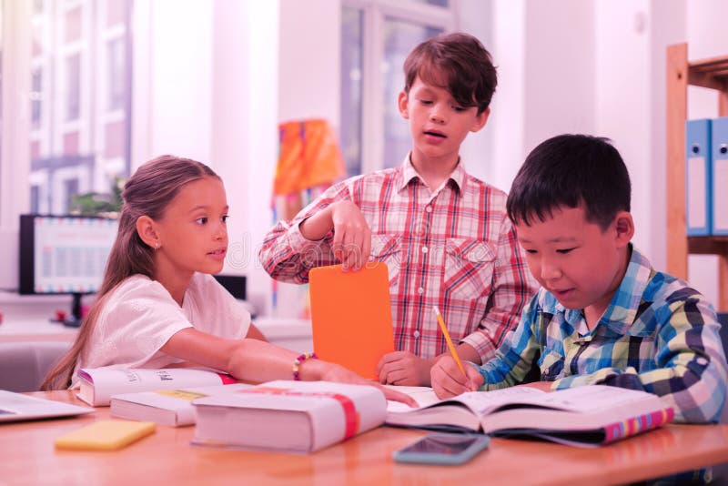 Three Smart Children Making Their Classwork Together. Stock Image ...